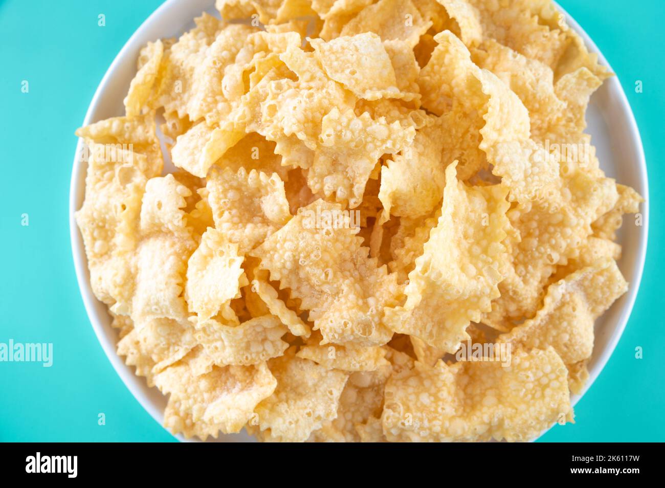 Sfrappole or chiachiere or angel wings on a bright blue background ...