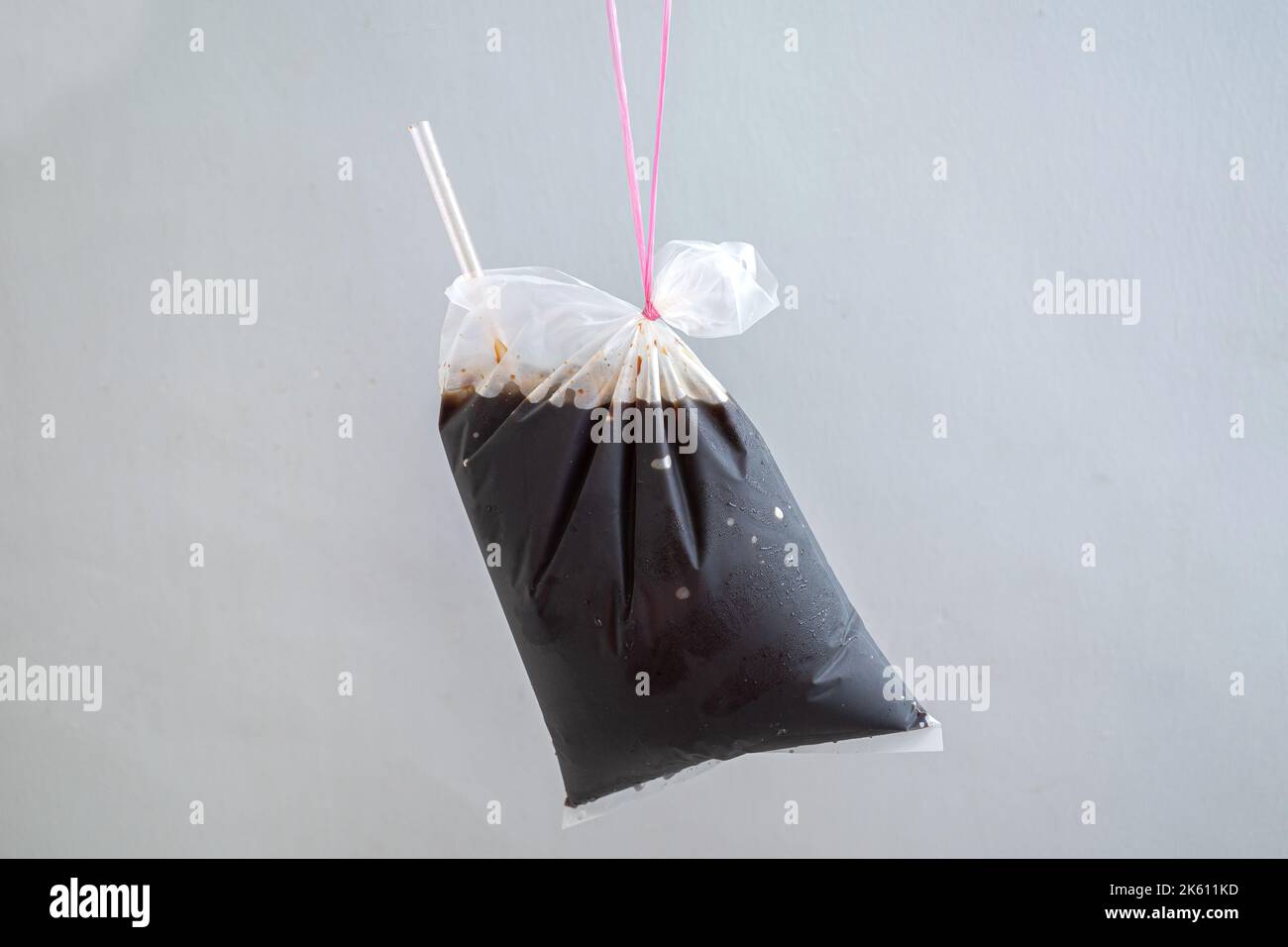 A Malaysian style take away black coffee drink in a plastic packet ...