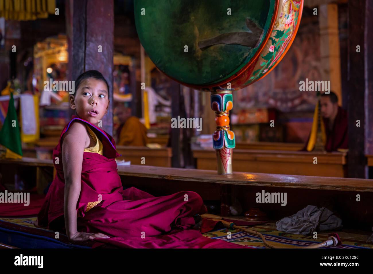 A young monk with a drum at Spituk Monastery (Gompa) during morning ...