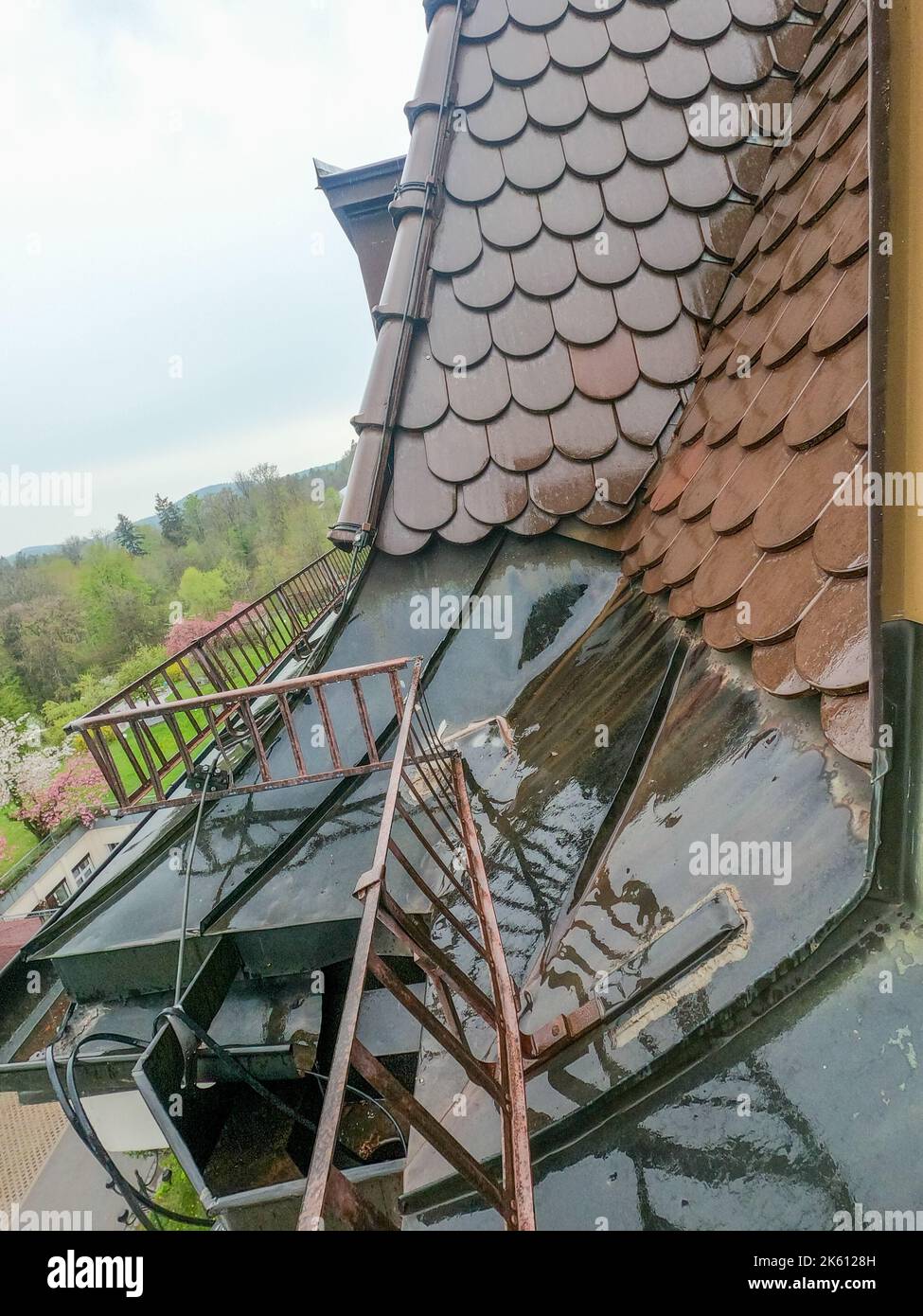 A vertical shot of fish scale roof shingles of a house on a rainy day ...