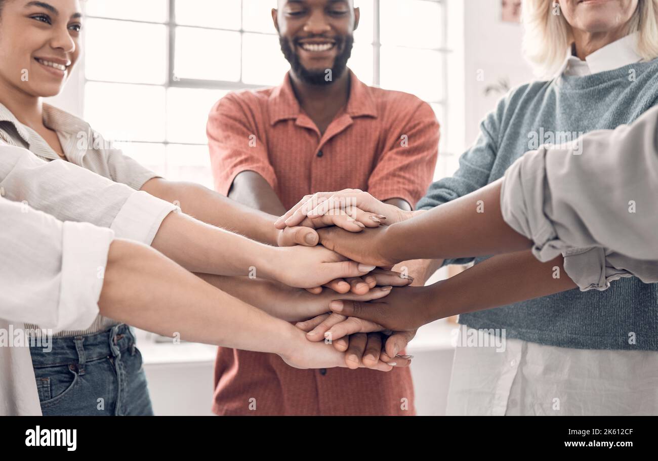Group of diverse businesspeople piling their hands together in an ...