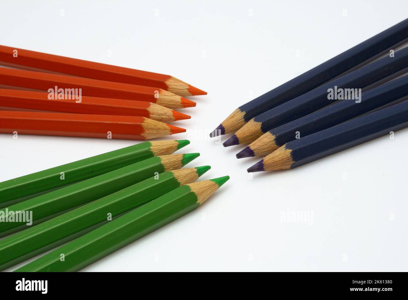 Wooden crayons arranged according to colour and facing each other with ...