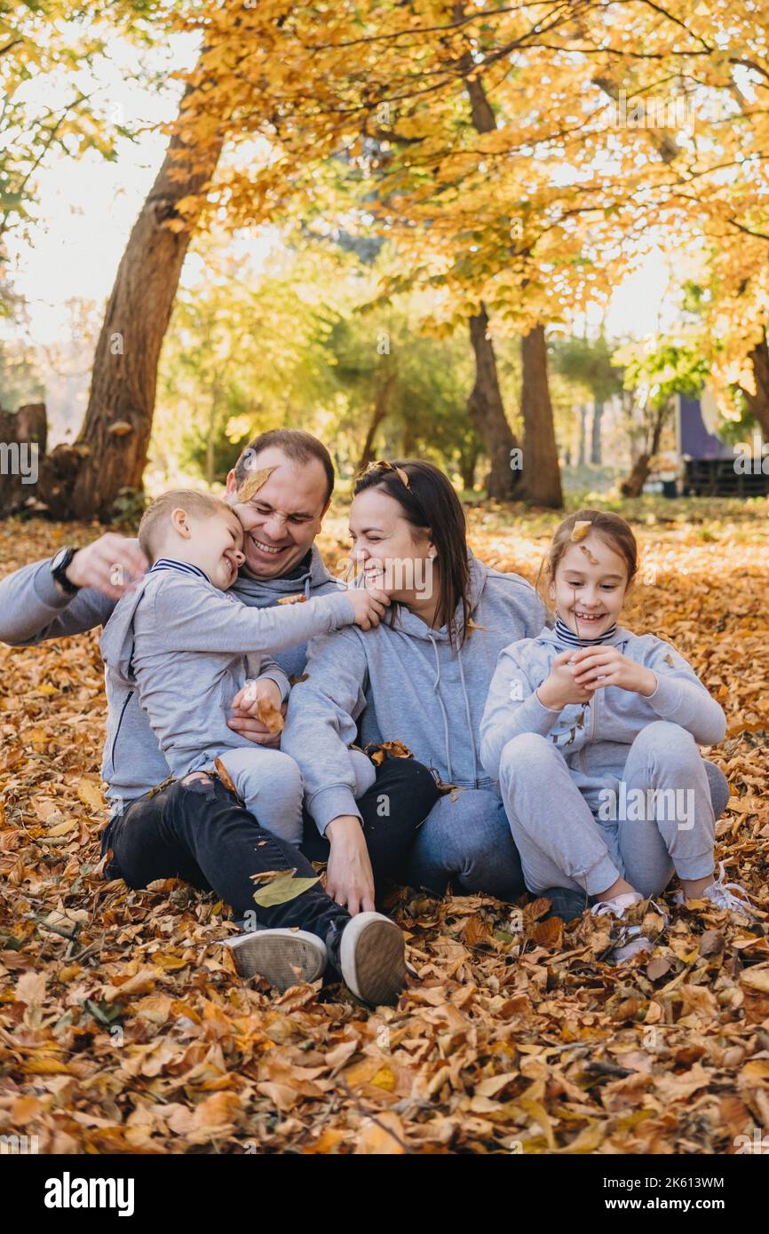 Loving mother and father spending leisure time at park with their kids ...