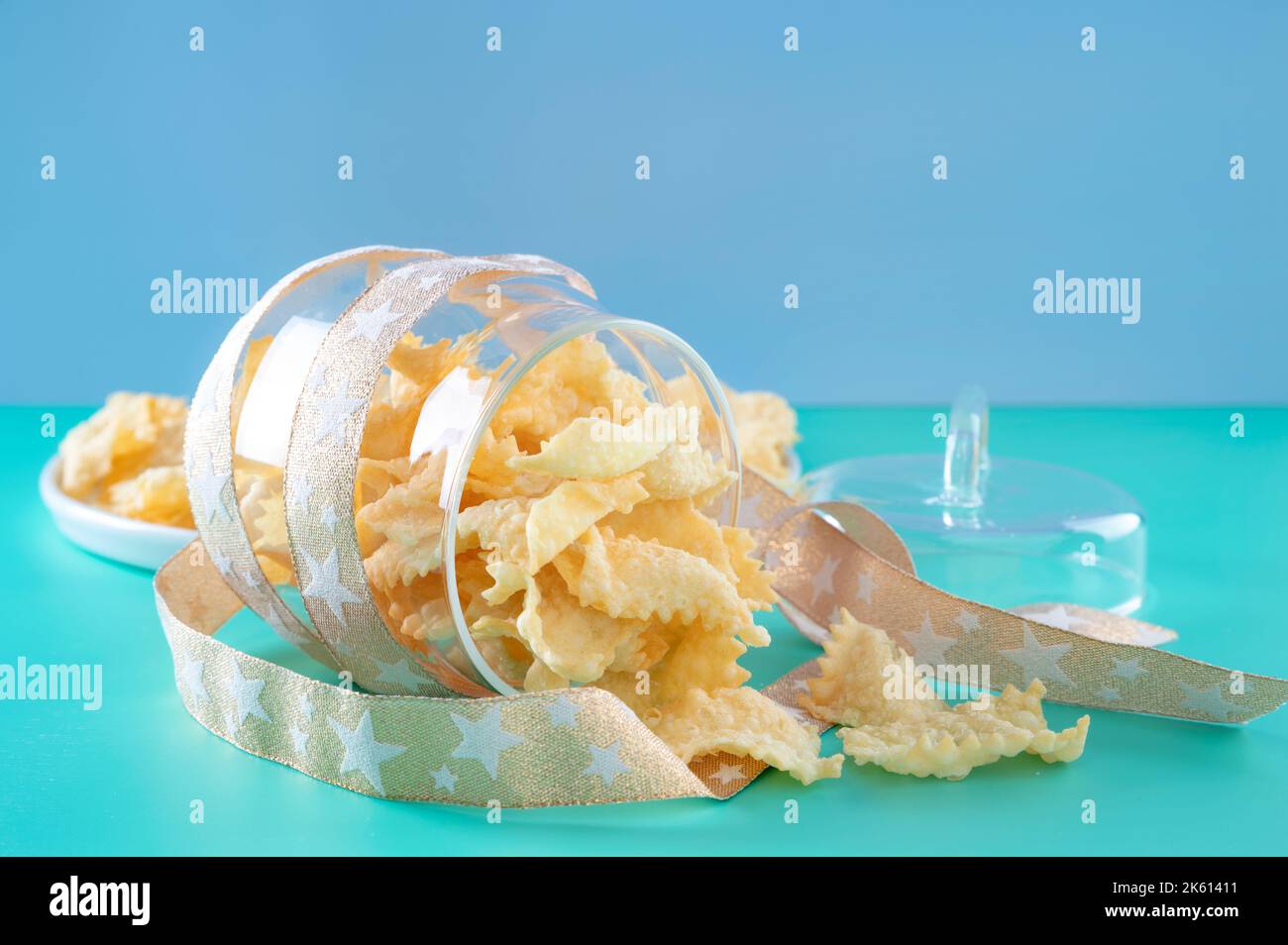 Sfrappole or chiachiere or angel wings on a bright blue background ...