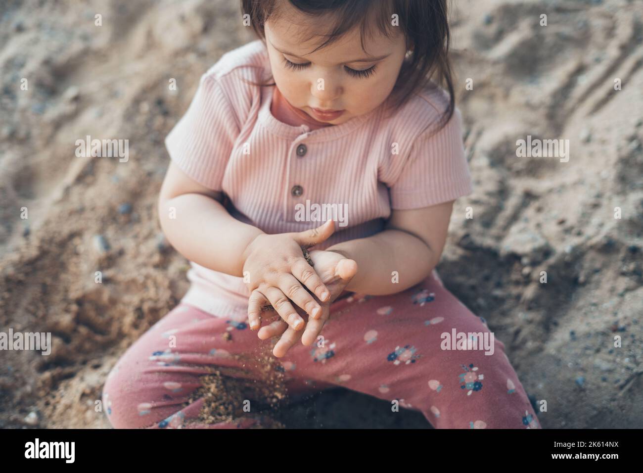 Portrait of a little baby girl having good time in summer garden ...