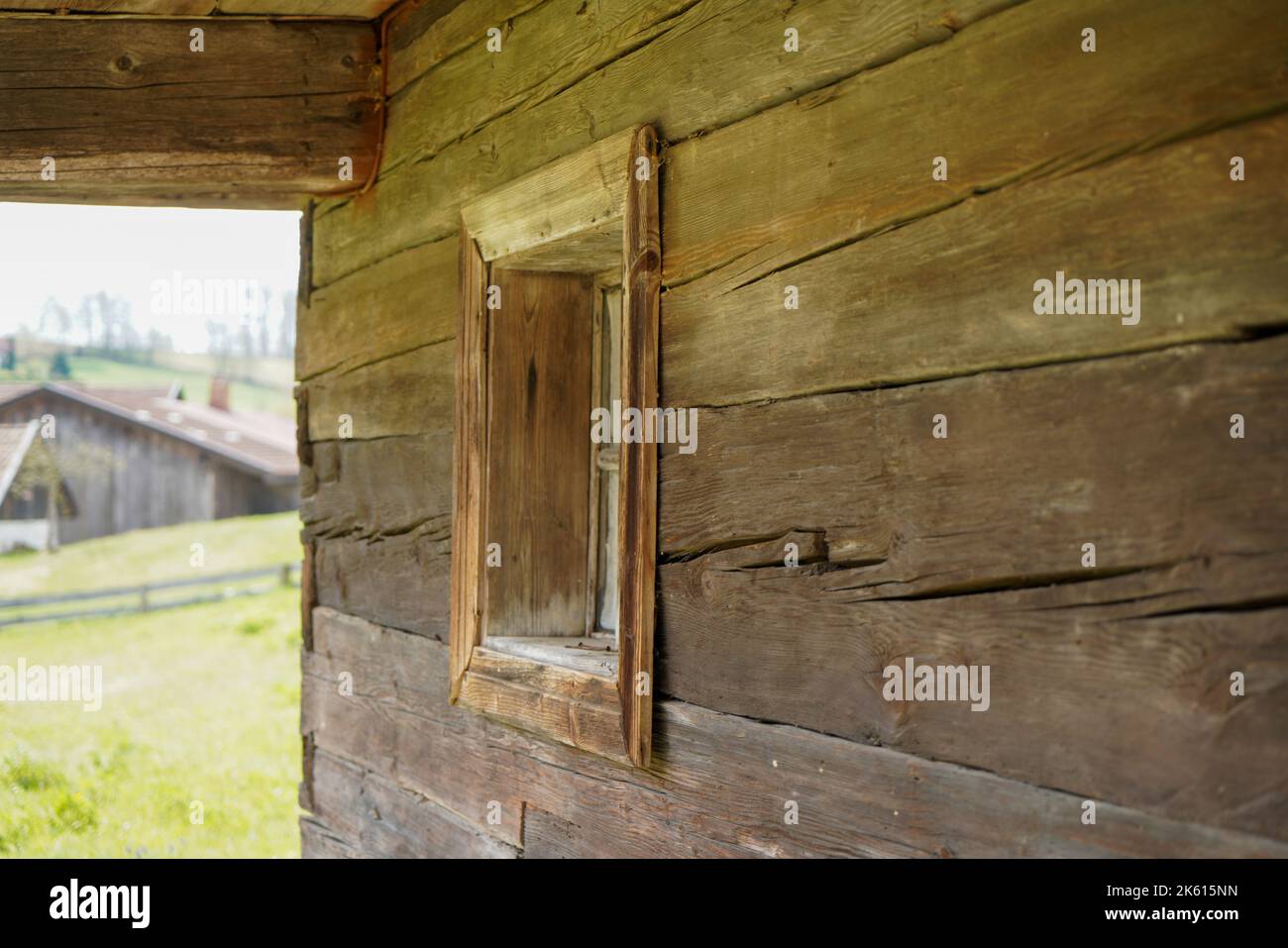 An old wooden house with a square small window in a village Stock Photo ...
