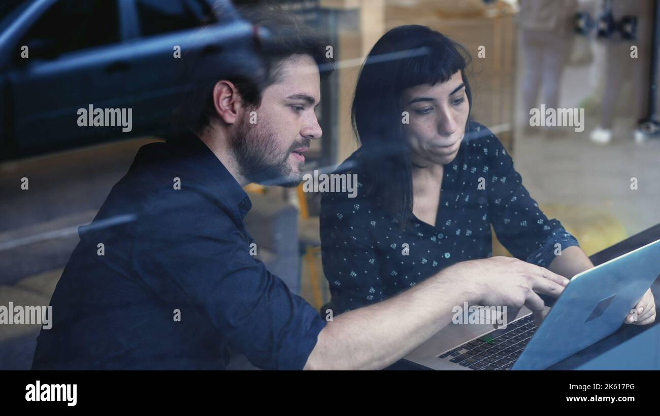 Two colleagues talking about work in front of laptop. Young man ...