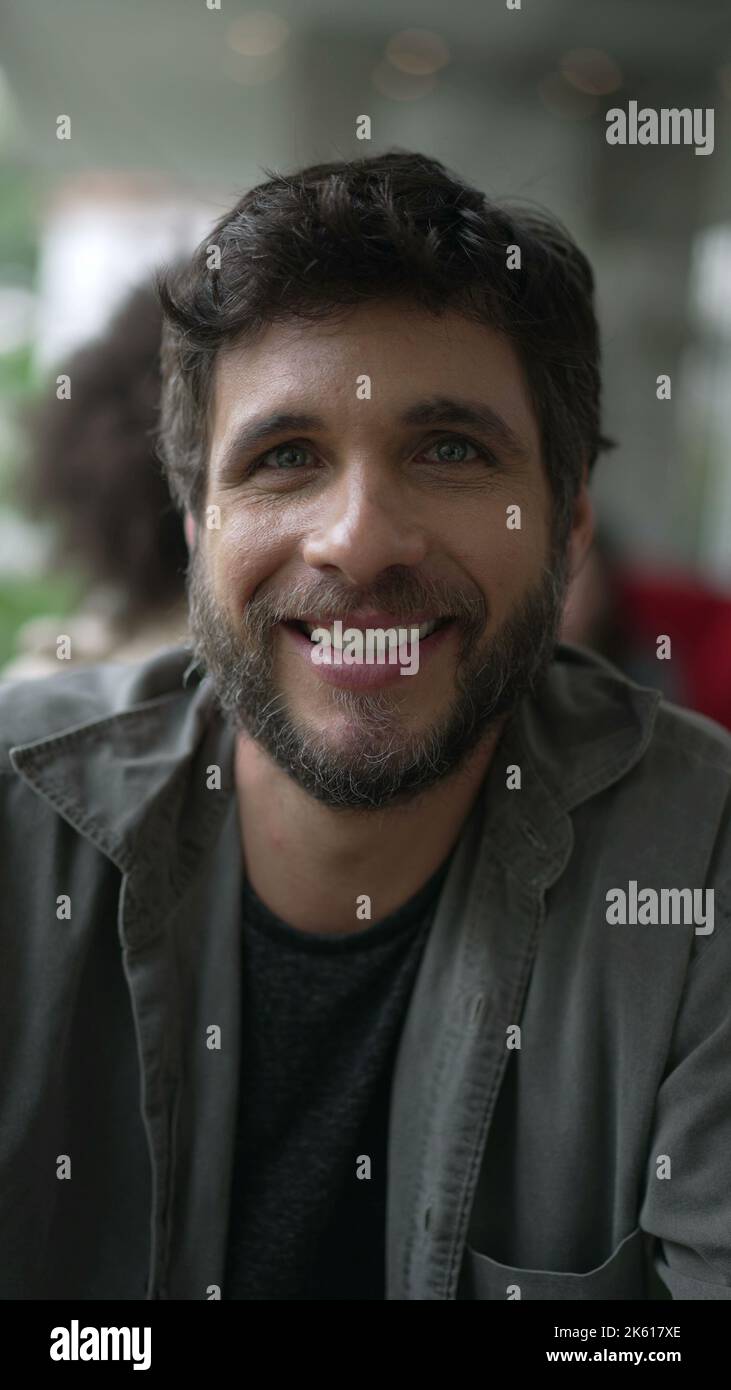 Portrait of a young man smiling at camera closeup face. Happy 30s person in Vertical Video SS ...