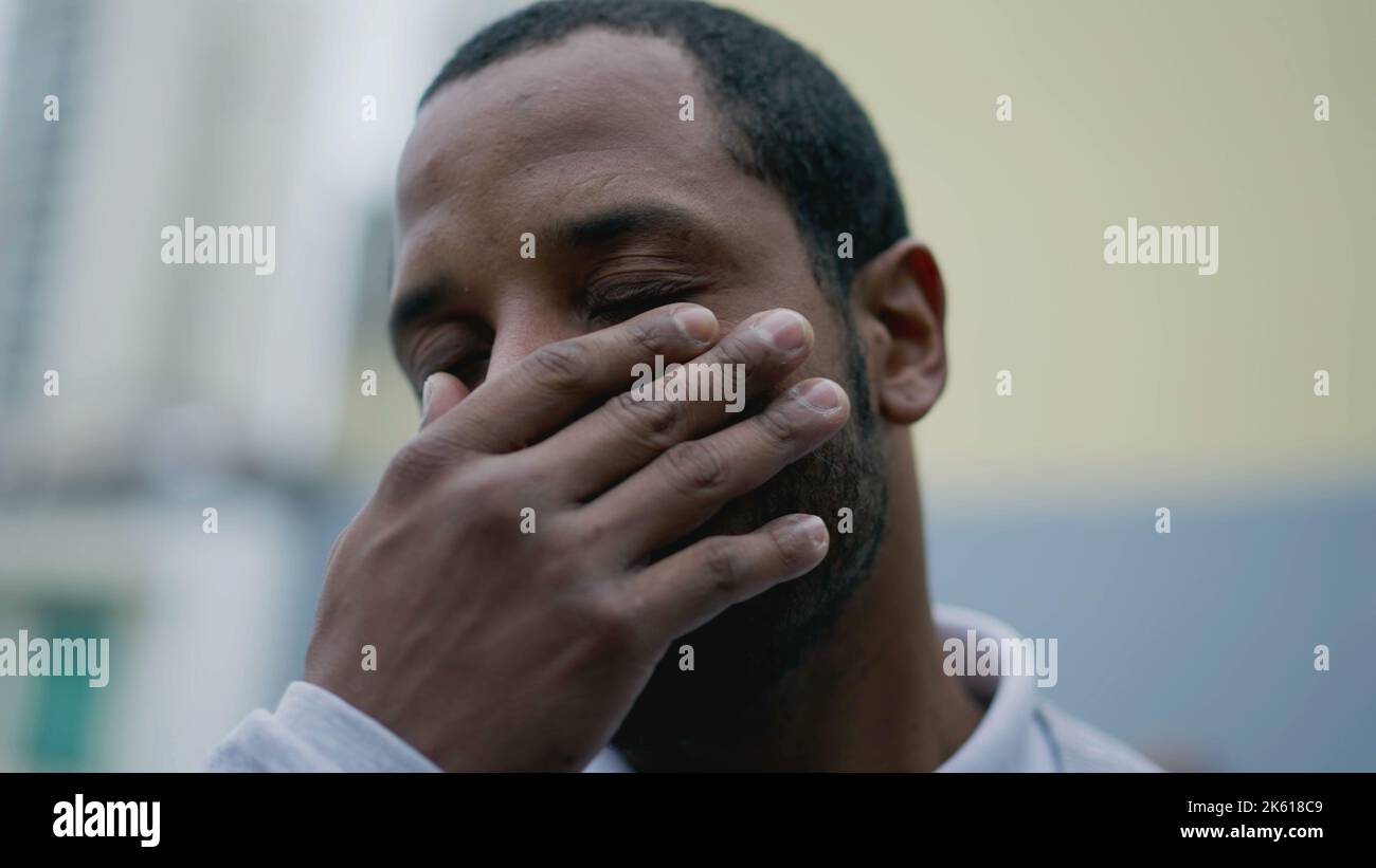 One pensive black man standing outdoors having worried frustration ...