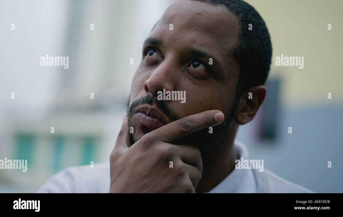 One pensive black man standing outdoors having worried frustration ...