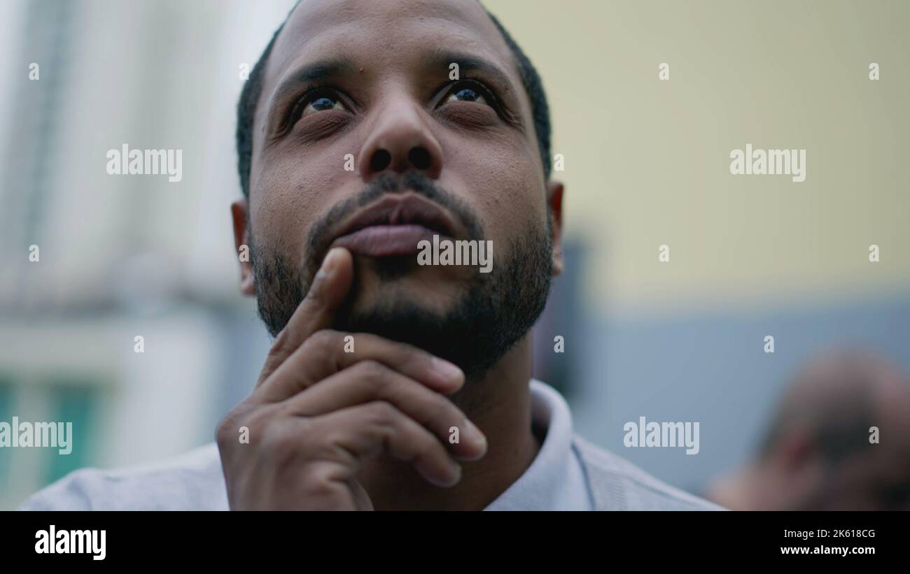 One pensive black man standing outdoors having worried frustration ...
