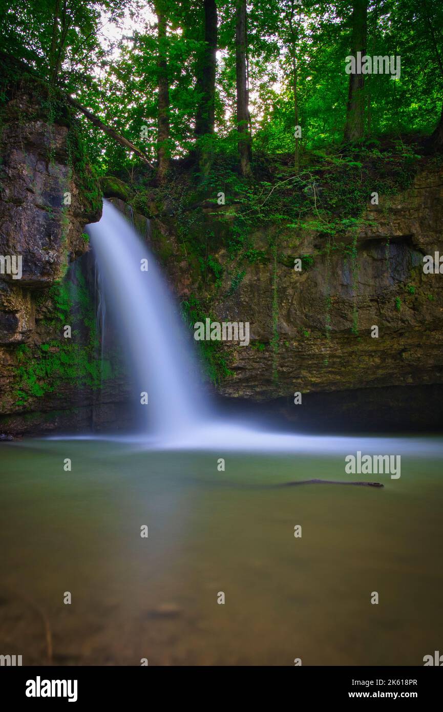 A beautiful scenery of a waterfall flowing downstream in a forest Stock ...