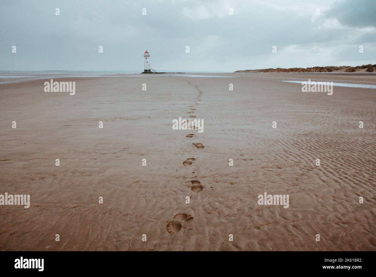 A footsteps on the beach with Talacre lighthouse in the background ...