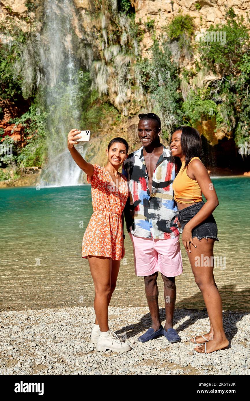 Full body of cheerful diverse man and ladies taking self portrait on ...