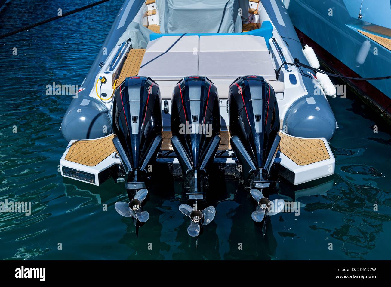 Three outboard powerful boat engines on the transom of a boat in the ...