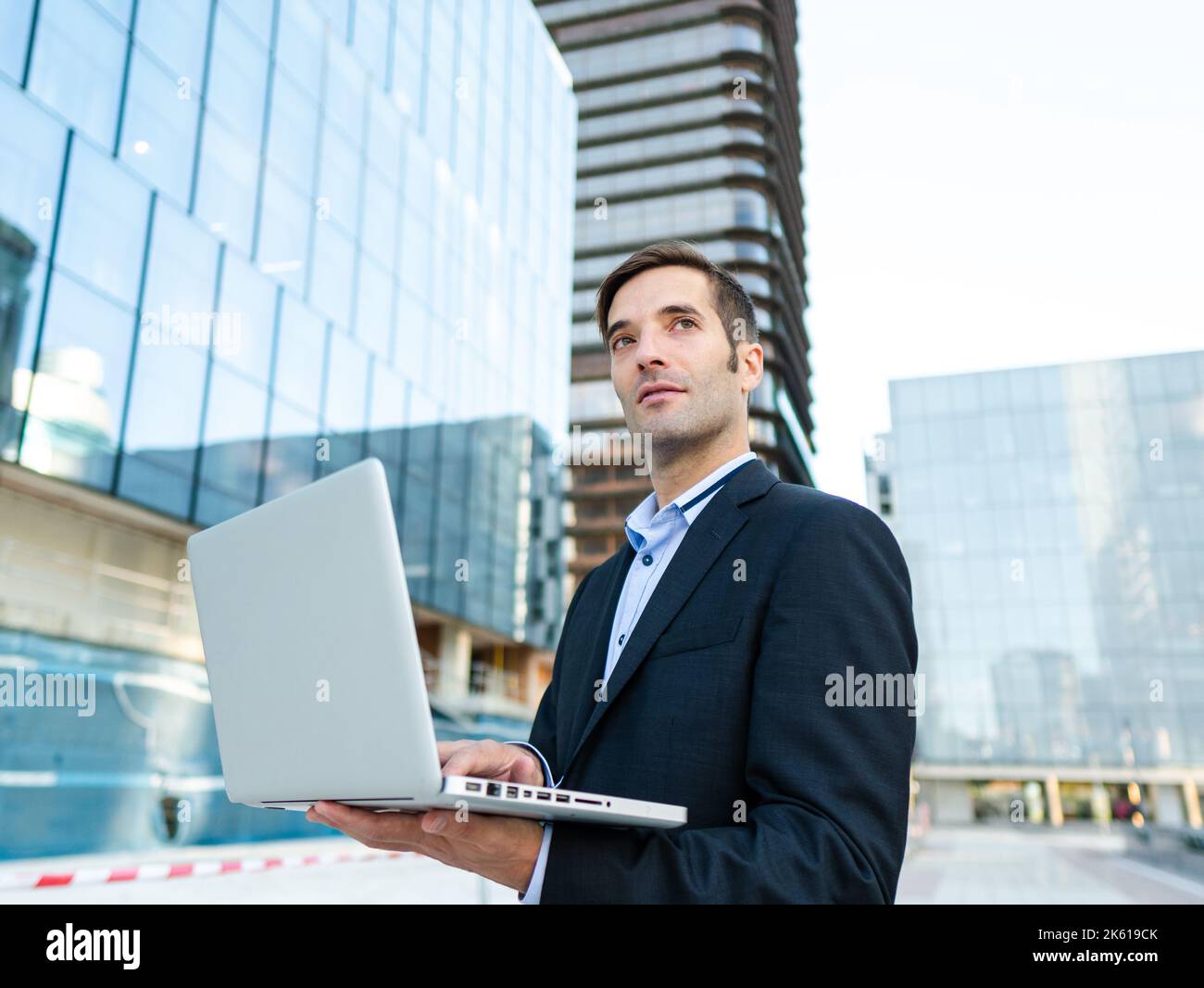 Low angle thoughtful entrepreneur in formal wear looking away while ...