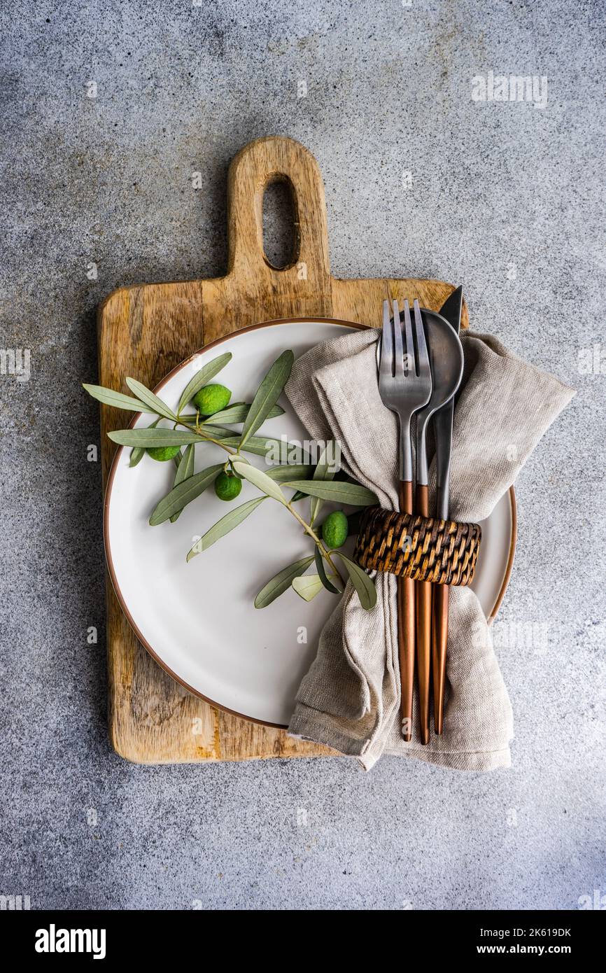 Rustic summer table setting with plate and cutlery decorated with Olive ...