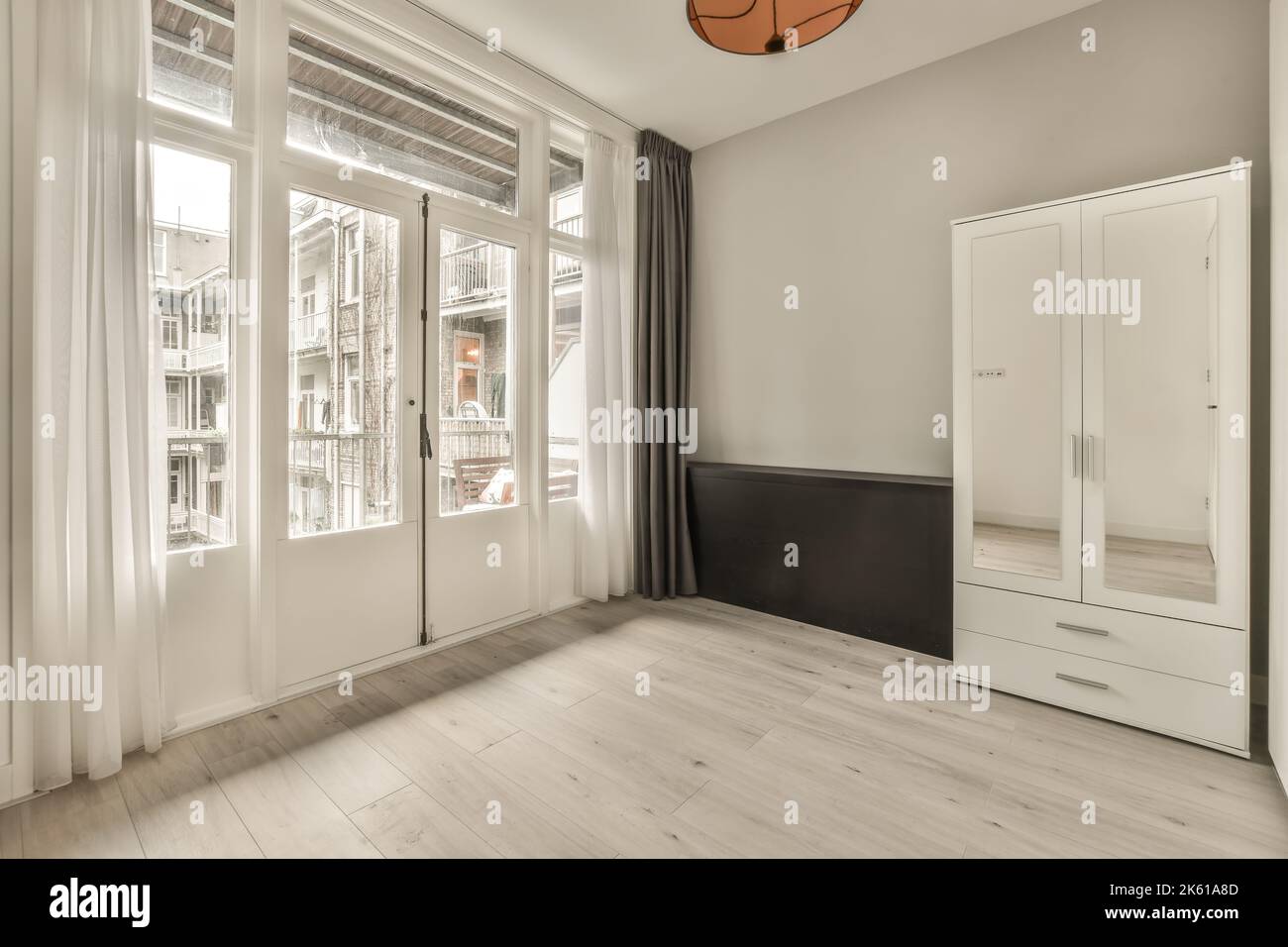 Spacious empty room in light apartment with closed glass doors leading ...