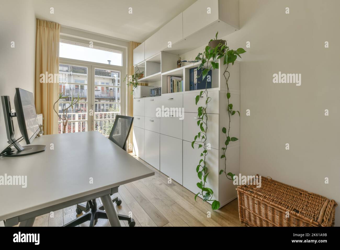 Desktop with modern computer placed near window in light home office ...