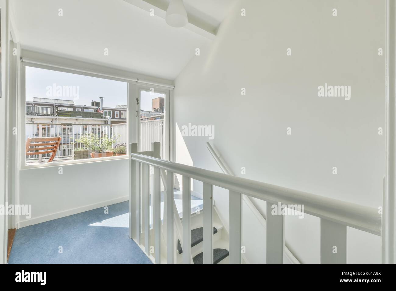 Light corridor with white fence and stairway placed near window with ...
