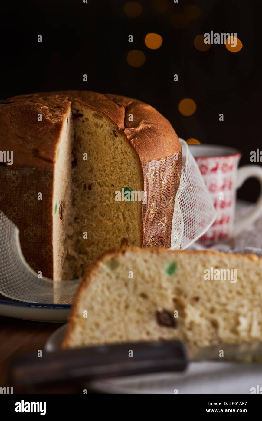 Sliced fresh baked artisan Christmas panettone cake under warm light ...