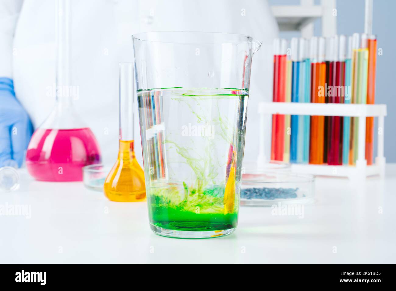 Colored liquids inside lab glassware on white table in laboratory Stock ...
