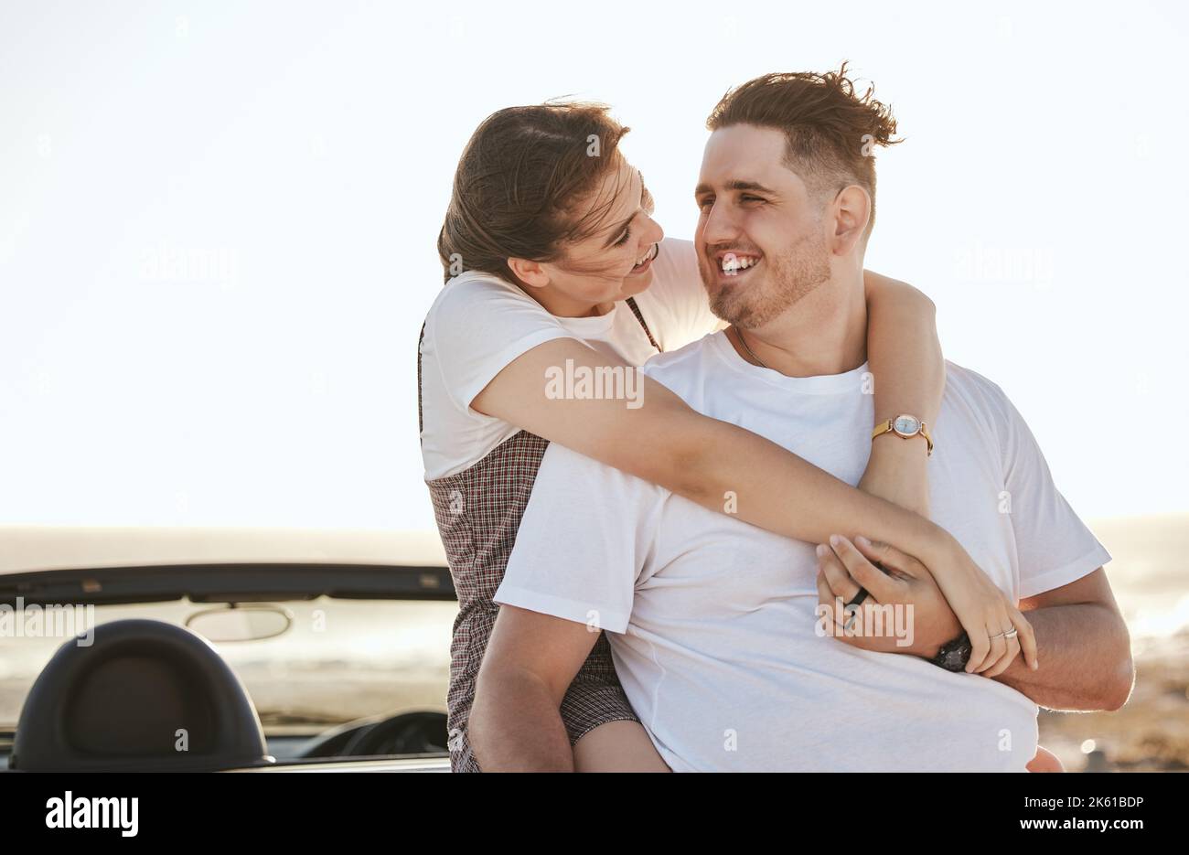 Couple, love and road trip travel of real people with a hug and smile ...