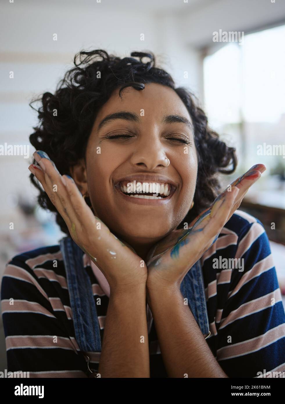 Woman artist, smile, happy and excited in her work studio, her hand ...