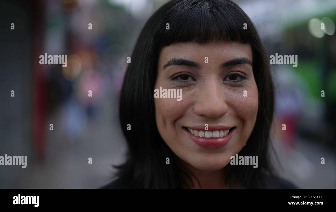 Contemplative young hispanic woman closing eyes in street. South ...