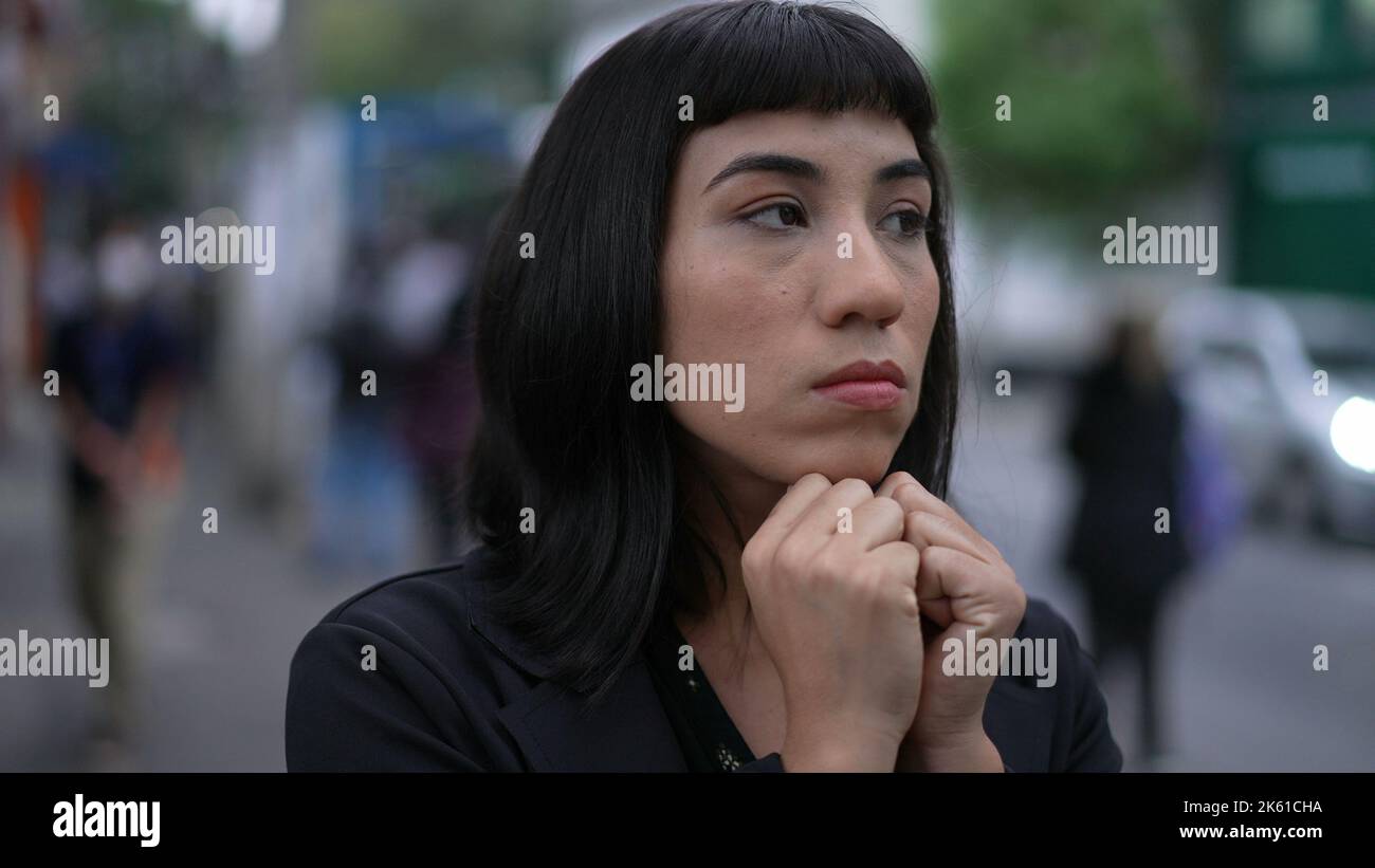 Nervous young woman standing in street feeling anxiety and stress ...