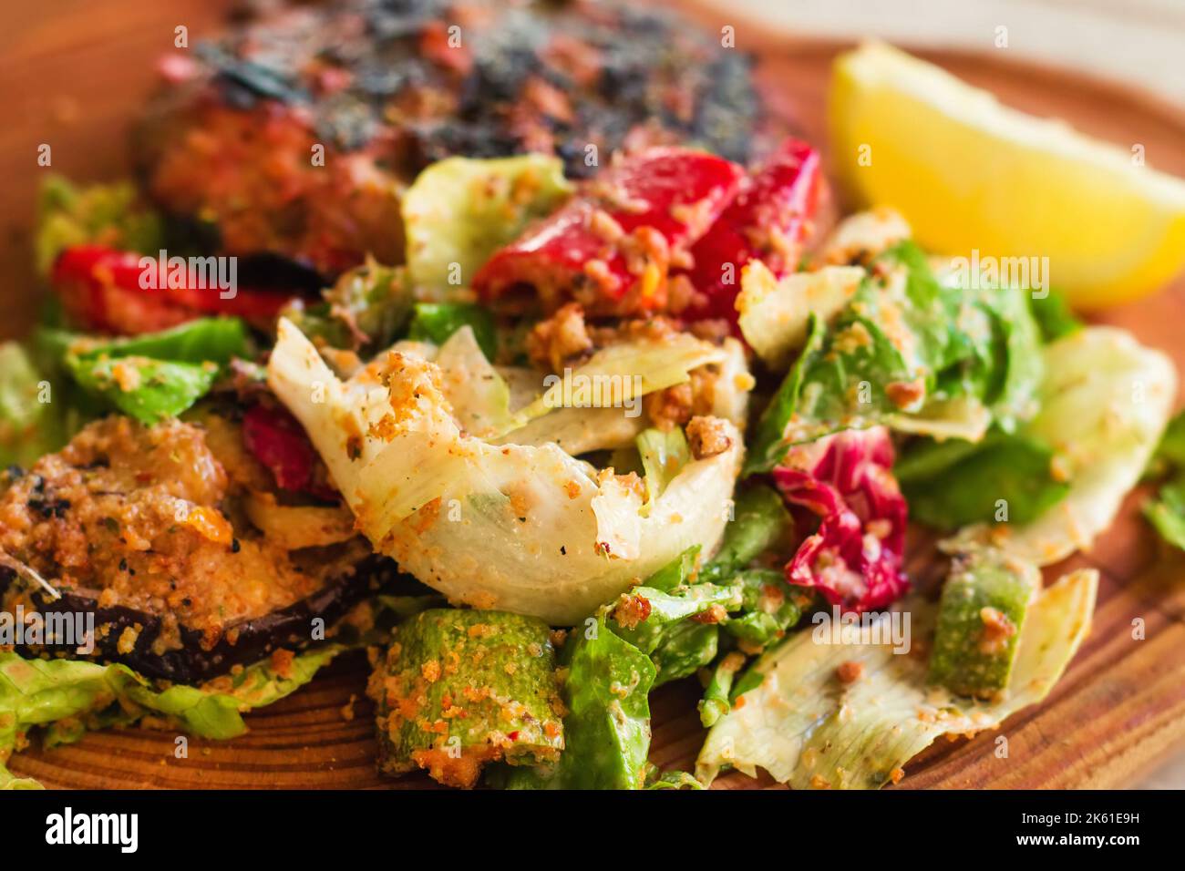 Low carb (bunless) burger served on a rustic wooden board with salad ...