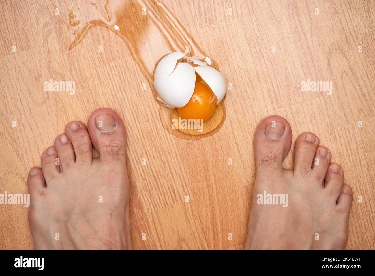 broken egg and feet on the floor in kitchen Stock Photo - Alamy
