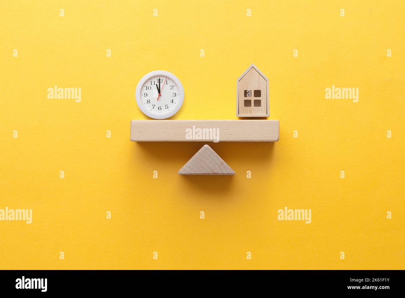 House and clock balanced on seasaw, life and work balance concept Stock ...