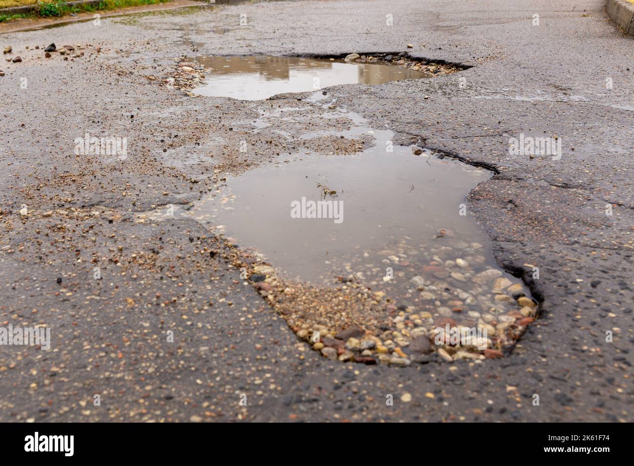 Water filled pot hole in the road. Copy space area for construction ...