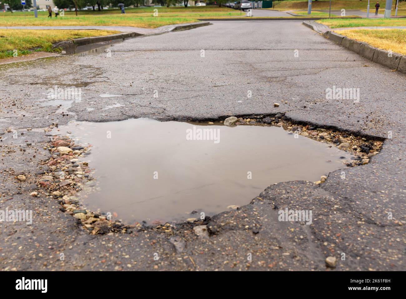 Water filled pot hole in the road. Copy space area for construction ...