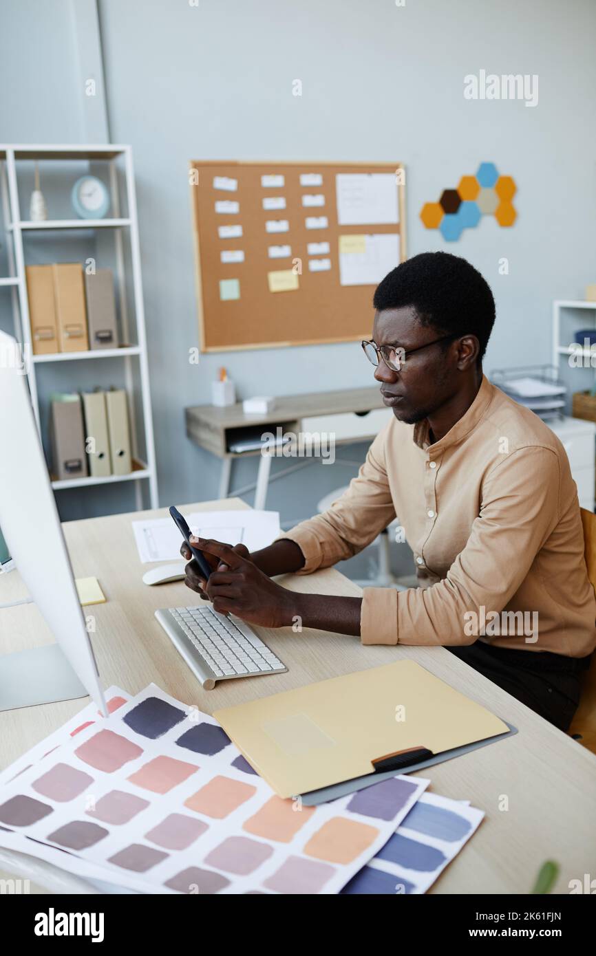 Vertical side view portrait of creative male designer using smartphone ...
