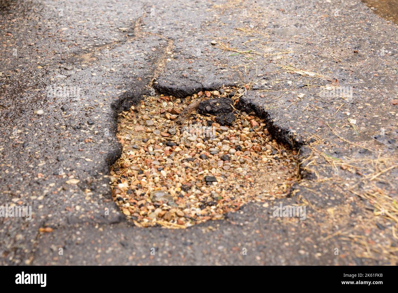 Water filled pot hole in the road. Copy space area for construction ...