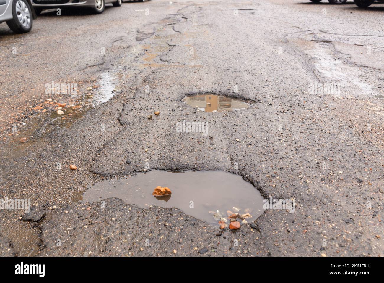 Water filled pot hole in the road. Copy space area for construction ...
