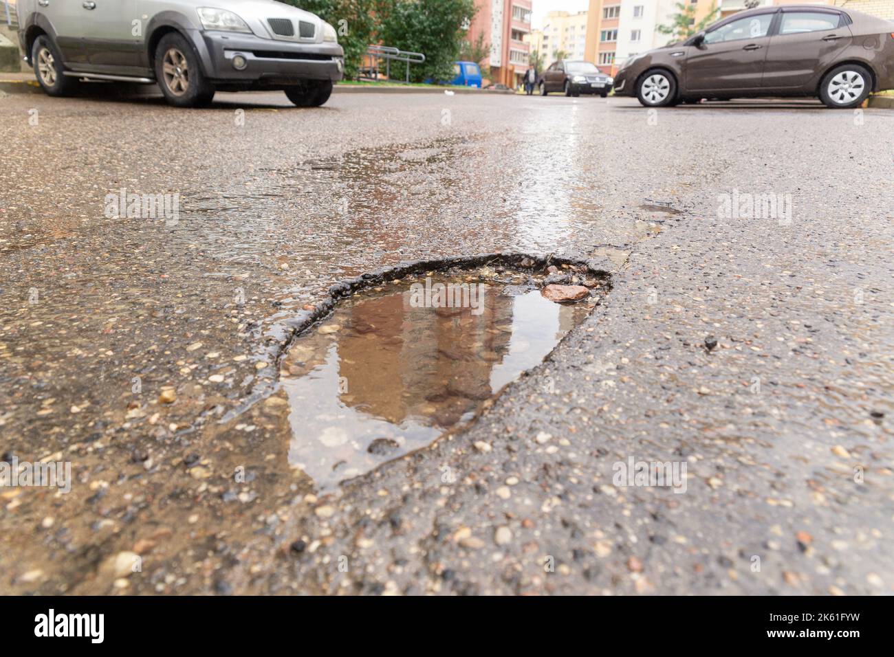 Water filled pot hole in the road. Copy space area for construction ...