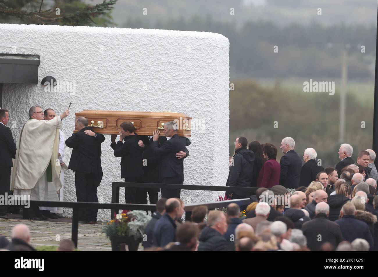 Priest Fr John Joe Duffy sprinkles holy water on the coffin of Martin ...