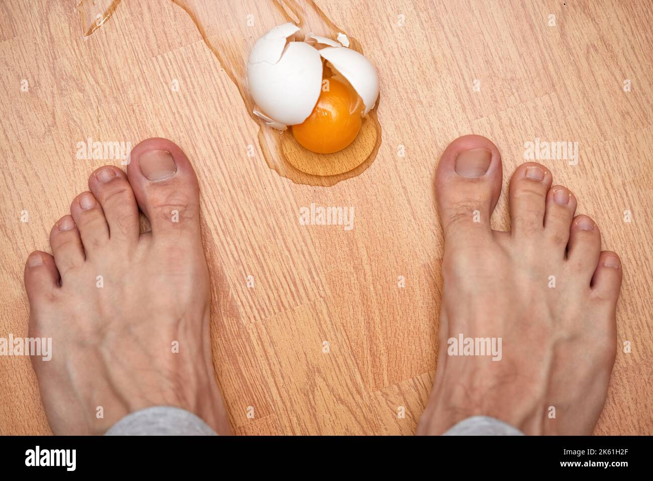 broken egg and feet on the floor in kitchen Stock Photo - Alamy