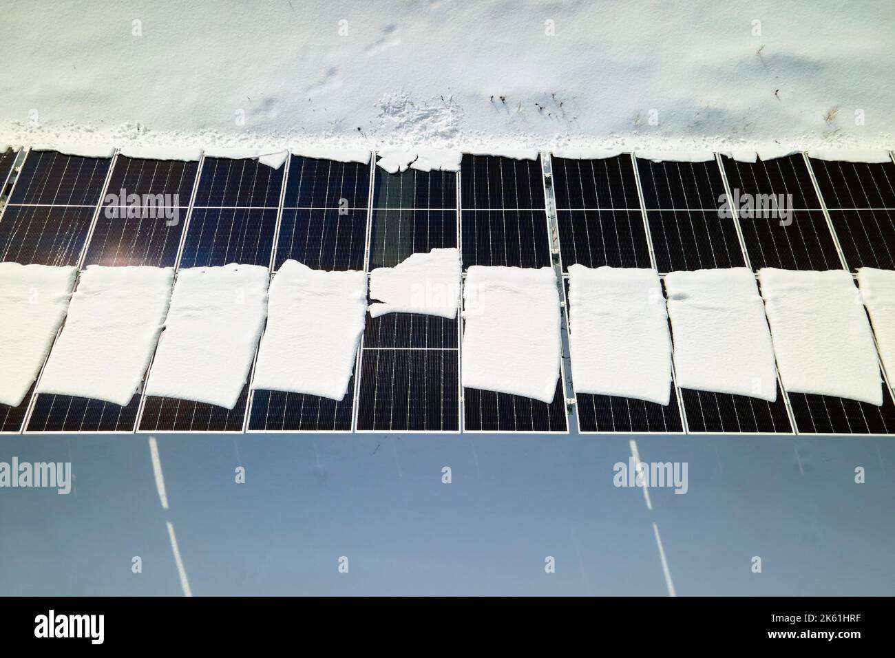Aerial view of snow melting from covered solar photovoltaic panels at ...
