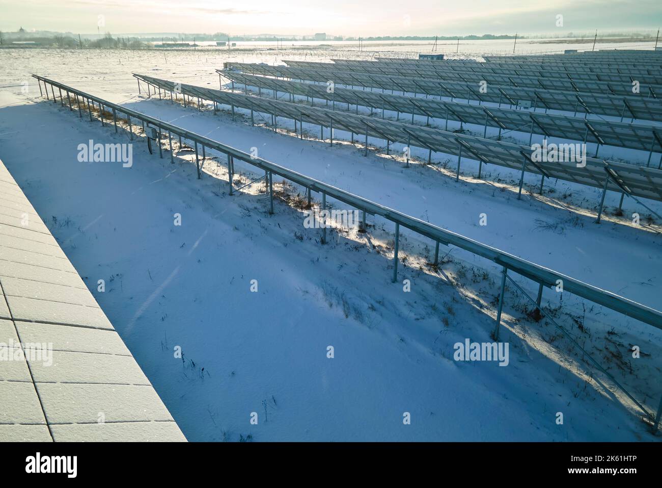 Aerial view of snow covered sustainable electric power plant with rows ...