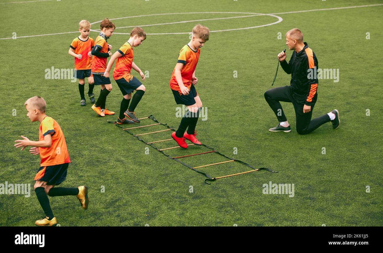 Workout. Junior soccer team training with football coach at sports ...