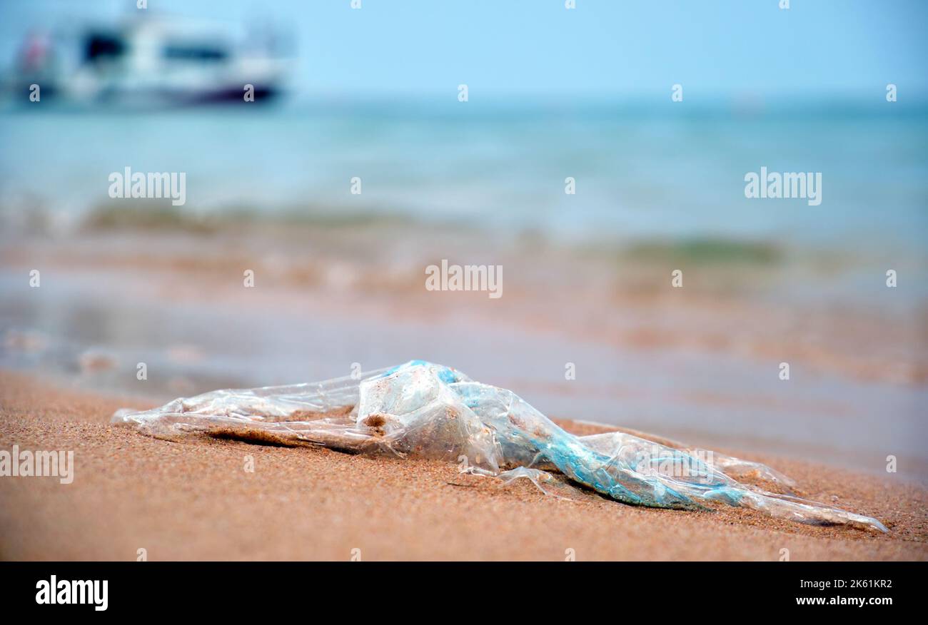 Left behind plastic bag garbage on sandy beach. Empty used dirty litter ...