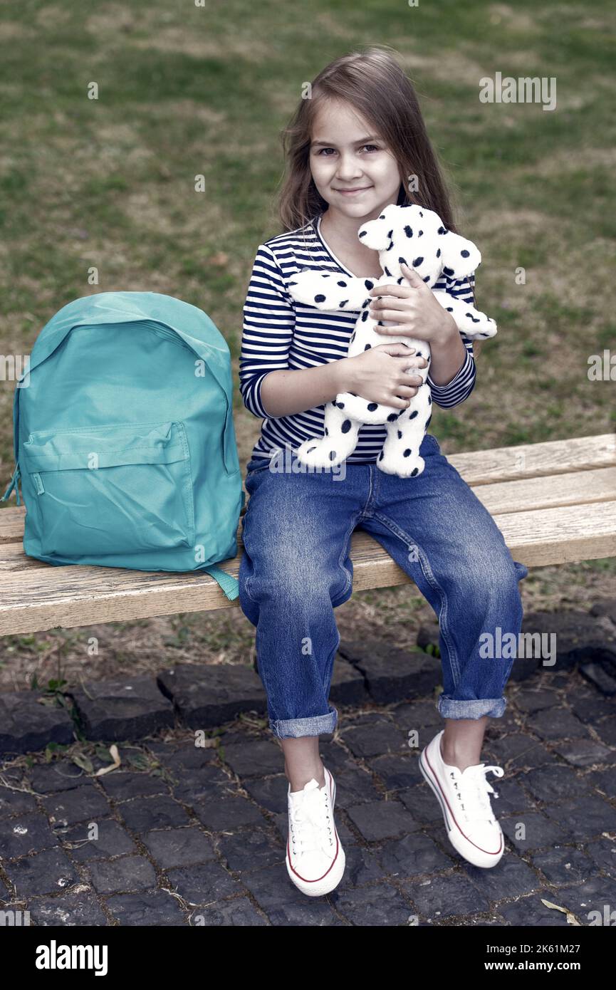 Play, learn and grow. Happy kid play with toy dog outdoors. Child ...