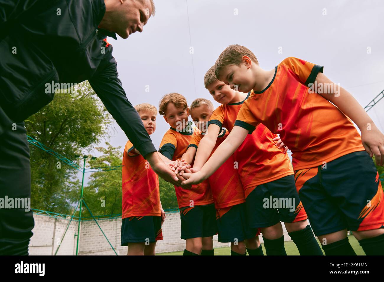 Determined to win. Junior soccer team stacking hands before a match ...