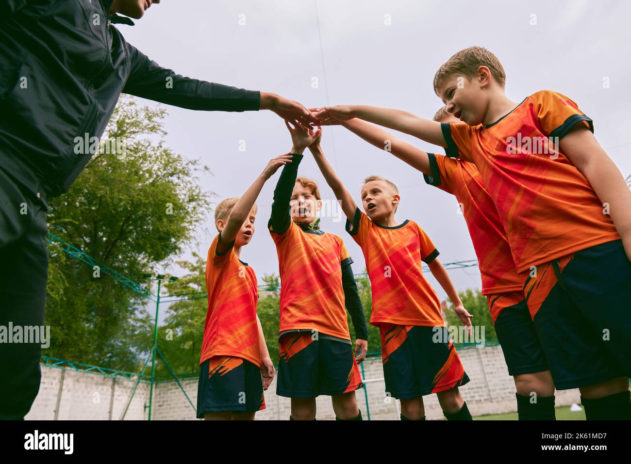 Determined to win. Junior soccer team stacking hands before a match ...