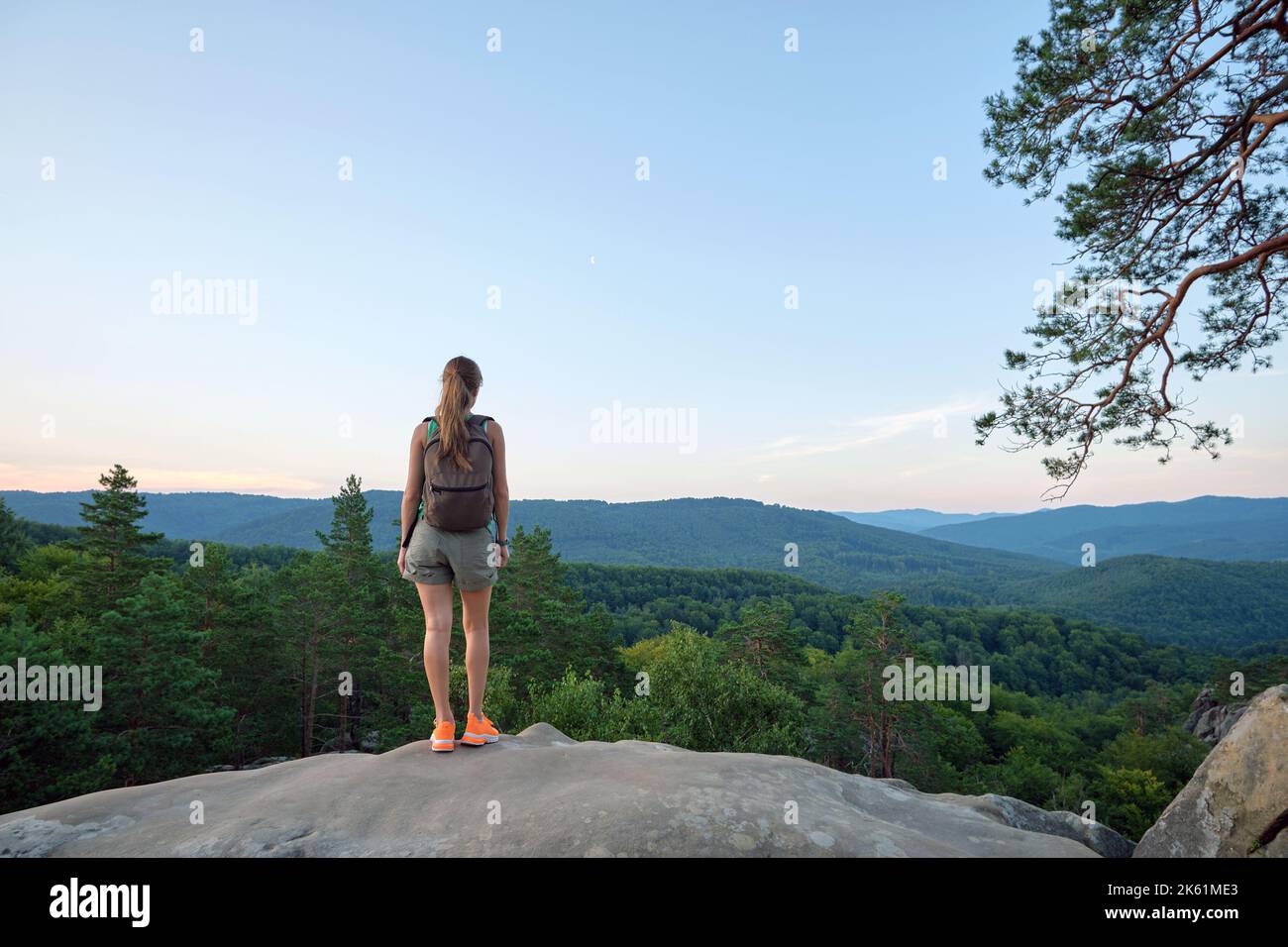 Sportive woman walking alone on hillside trail. Female hiker enjoying ...
