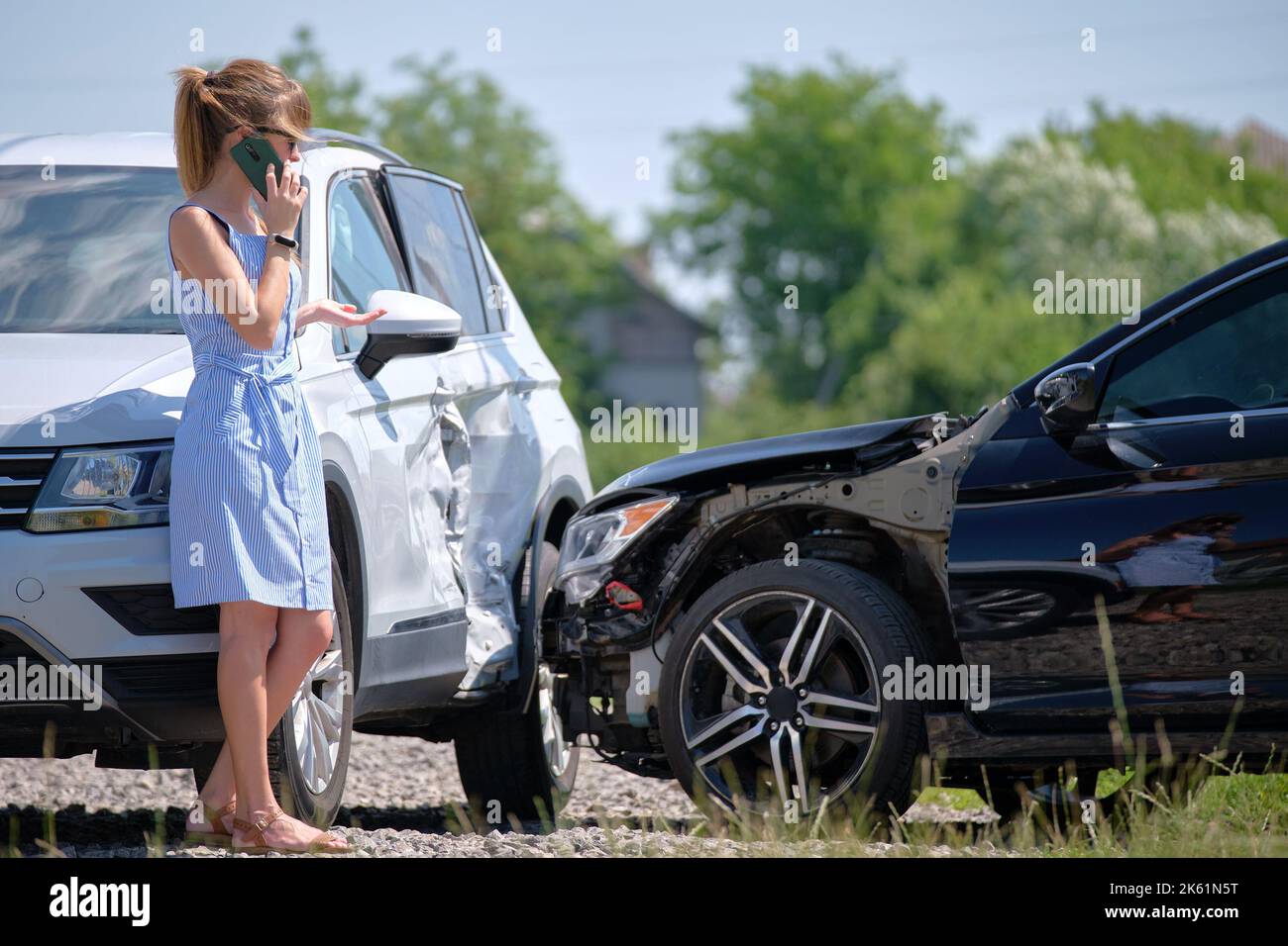 Stressed driver talking on sellphone on roadside near her smashed ...